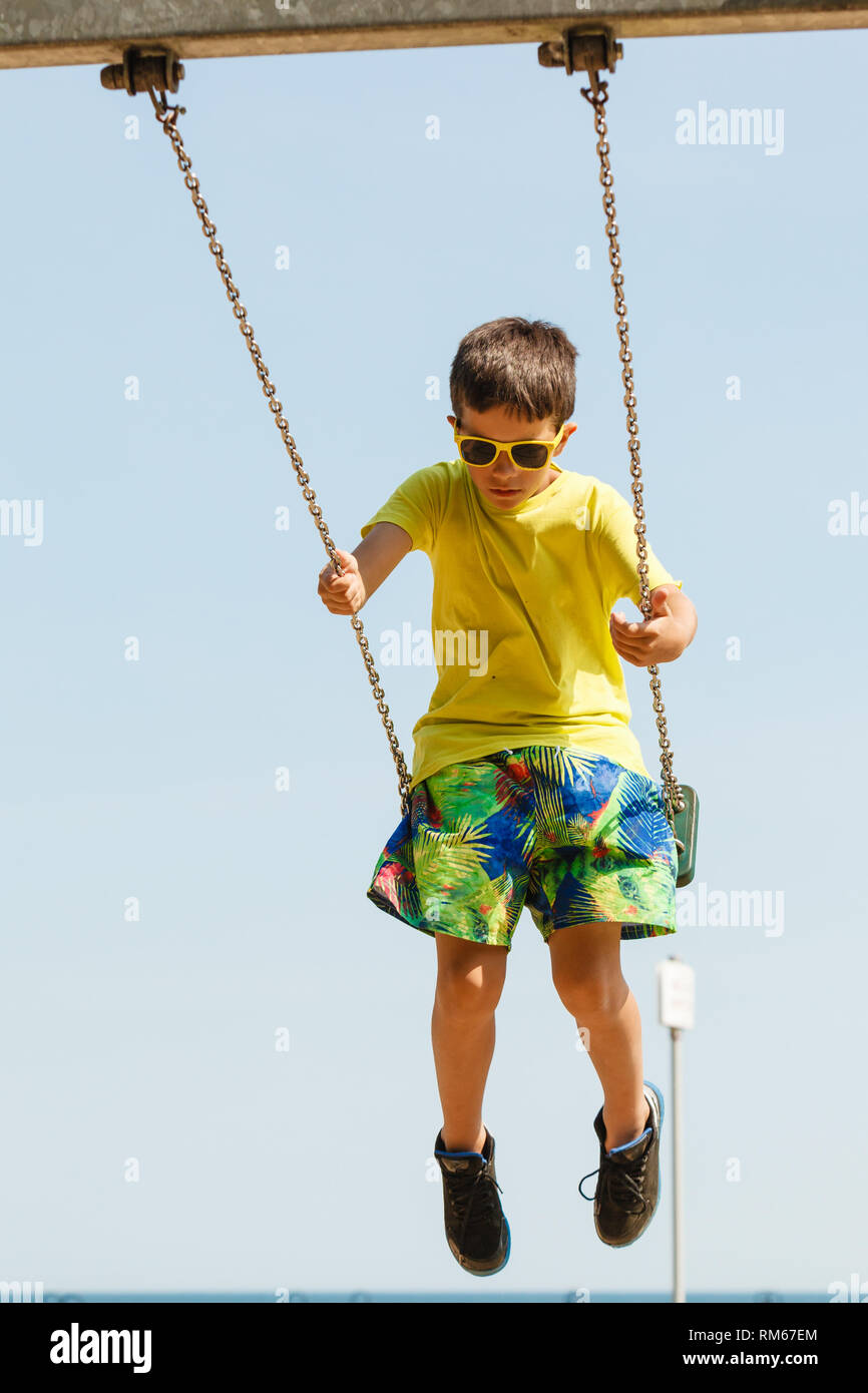 Rest and relax for children. Little boy in sunglasses resting swinging ...