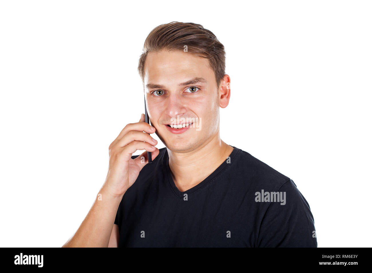 Portrait of a young man having a phone call and smiling to the camera ...