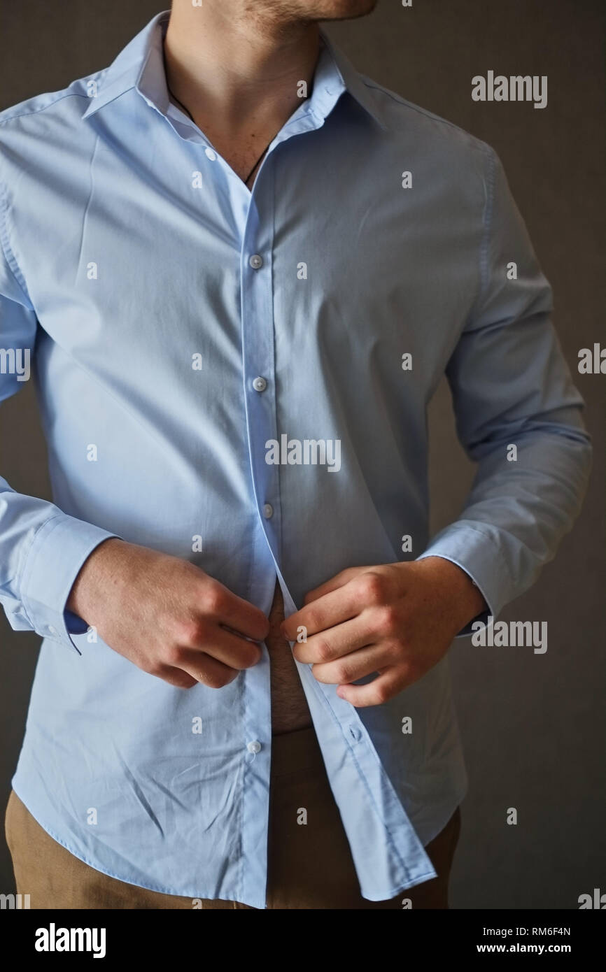 Man adjusting his shirt buttons Stock Photo - Alamy