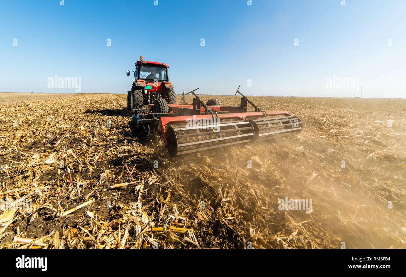 Tractors plowing stubble fields Stock Photo - Alamy