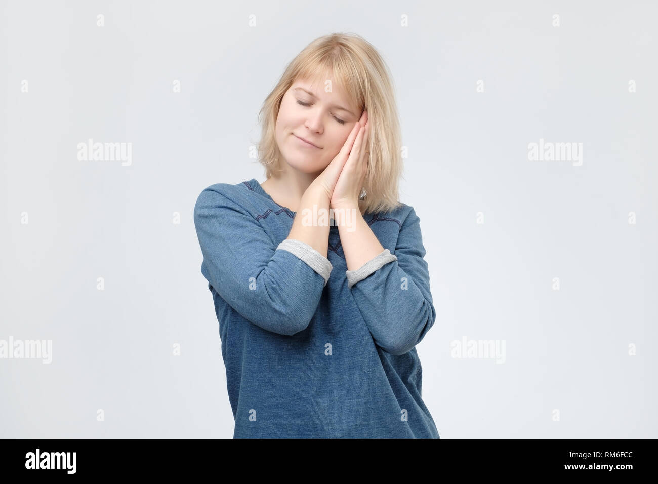 Blonde woman with happy serene face standing asleep pretending sleeping ...