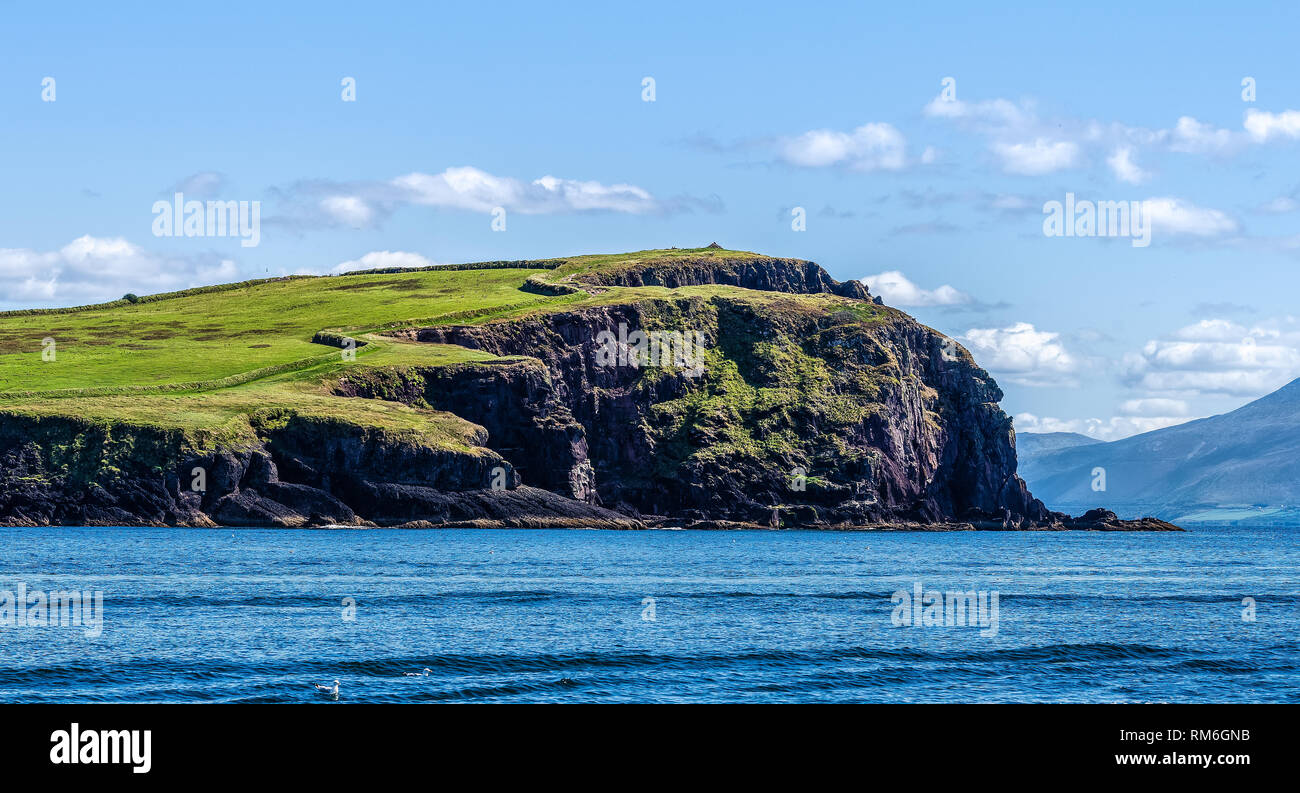 Green fields and high cliff with mountains in a distance – view from ...