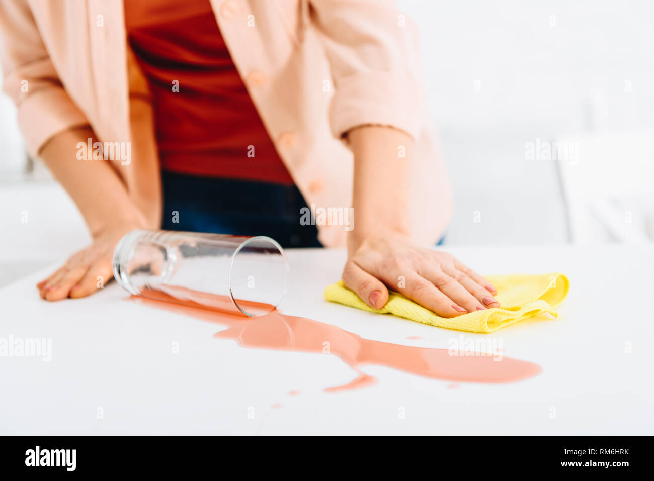 Partial view of woman wiping wine stain with rag Stock Photo - Alamy