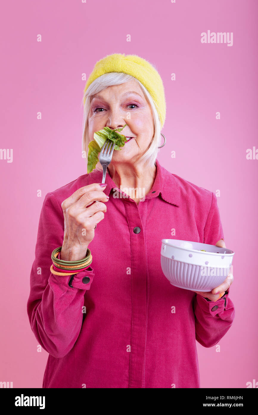 Beautiful elderly lady with bright makeup eating lettuce Stock Photo ...