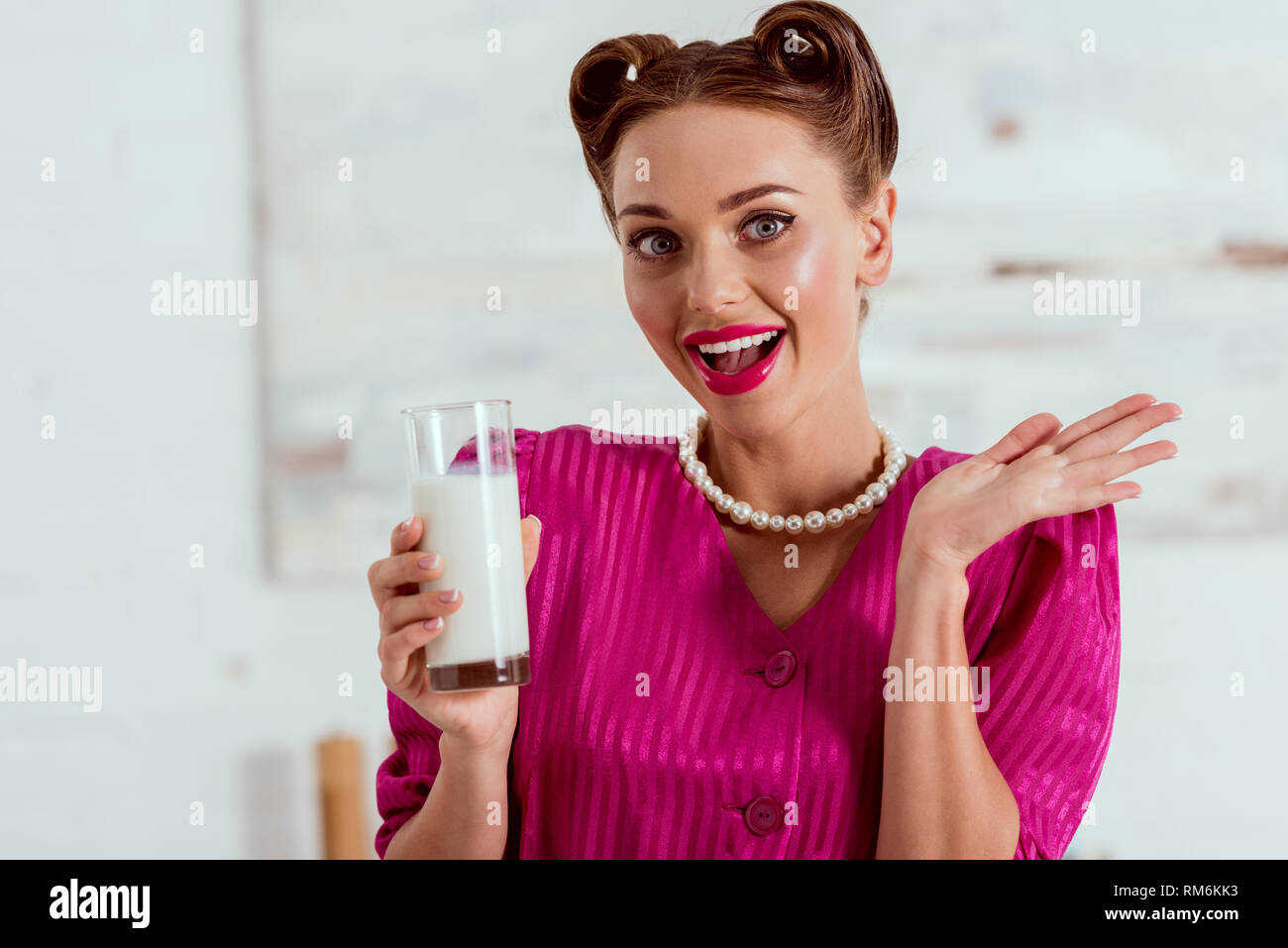 Beautiful pin up girl holding glass of milk and waving hand Stock Photo ...