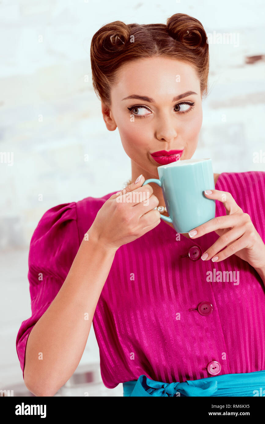 Attractive pin up girl in crimson dress drinking coffee Stock Photo - Alamy