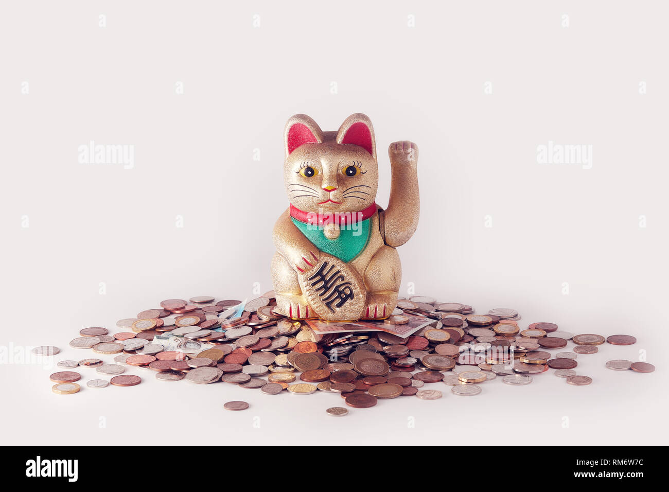 Lucky chinese cat and coins Stock Photo - Alamy