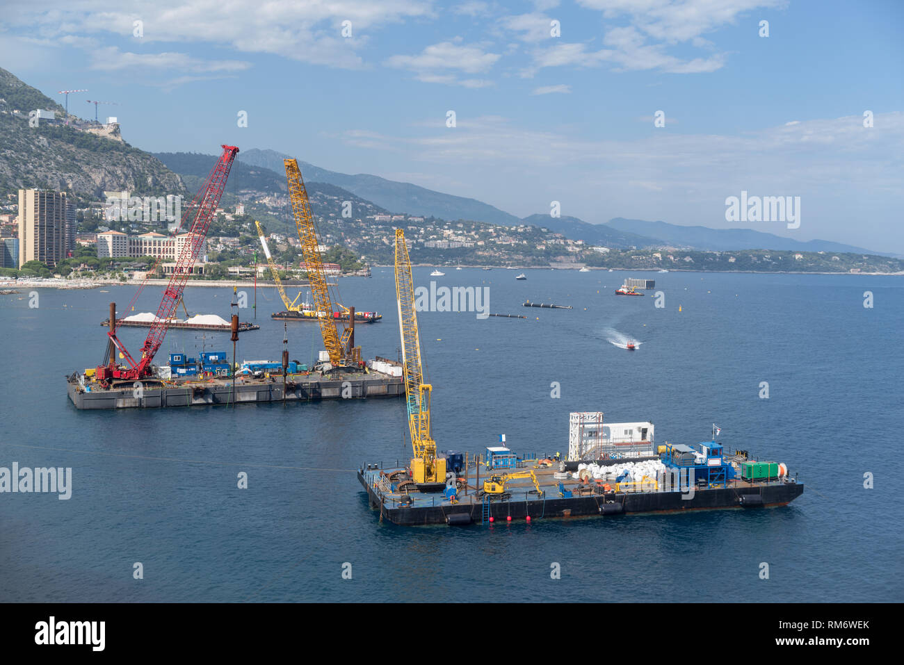 A construction crane barges begins land reclamation work off the coast ...