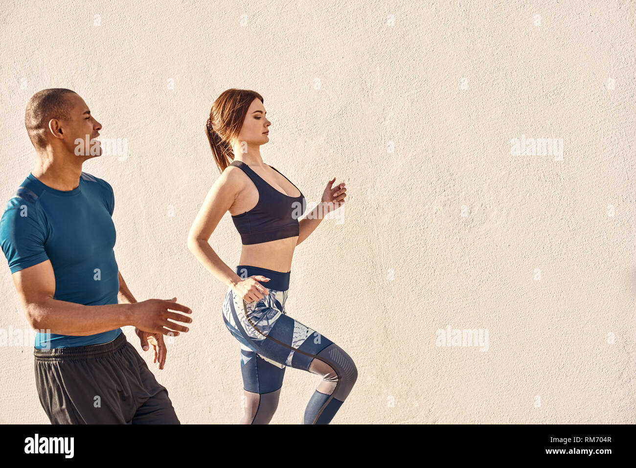 Healthy morning together. Young happy couple are training outdoors and ...