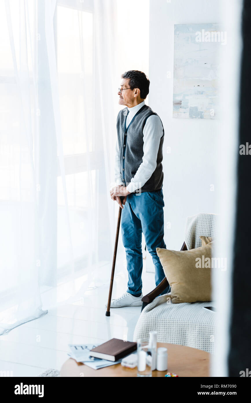 retired man standing with walking stick at home Stock Photo - Alamy