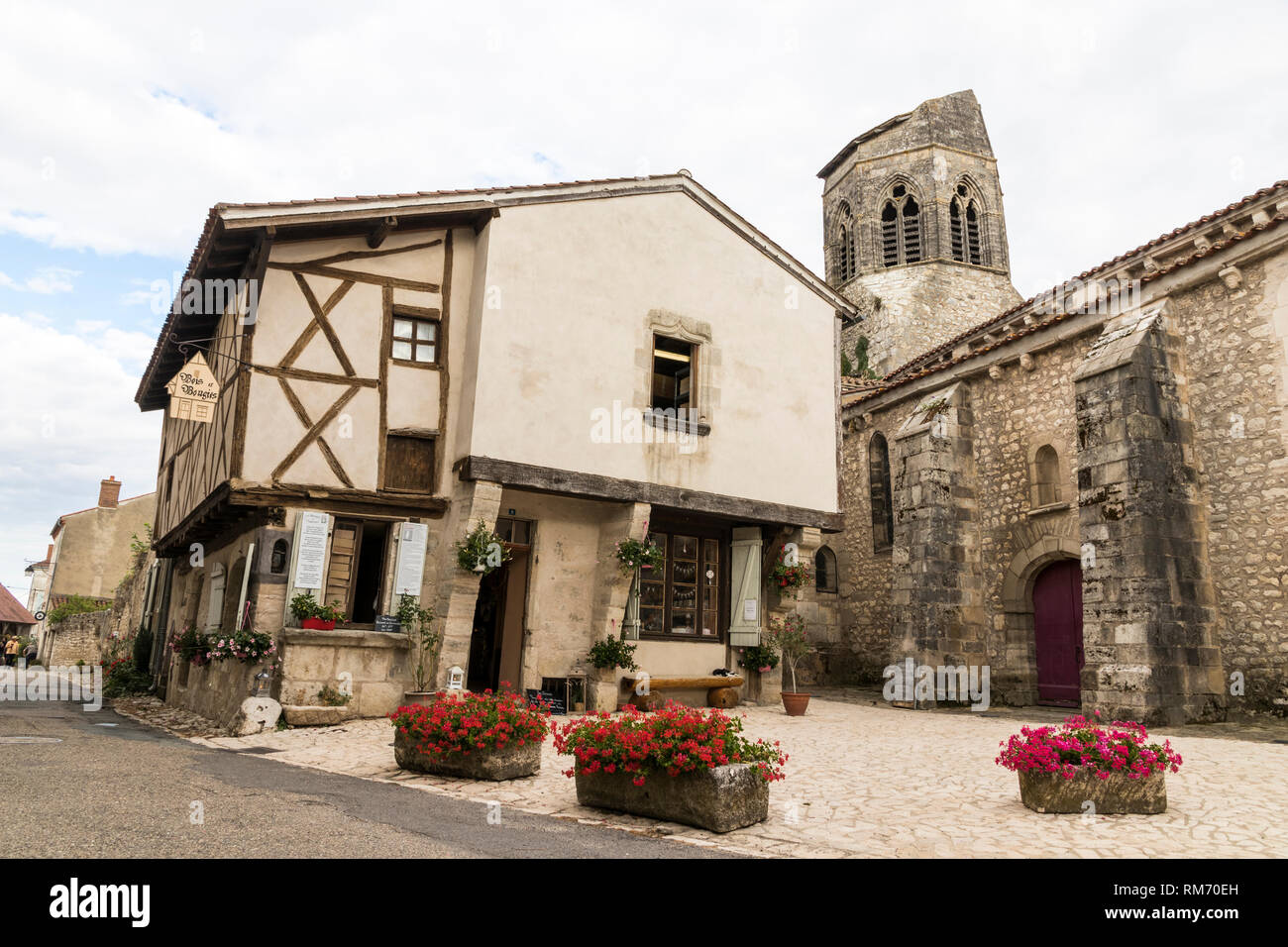 Charroux, France. Half-timbered house and church tower in one of the ...