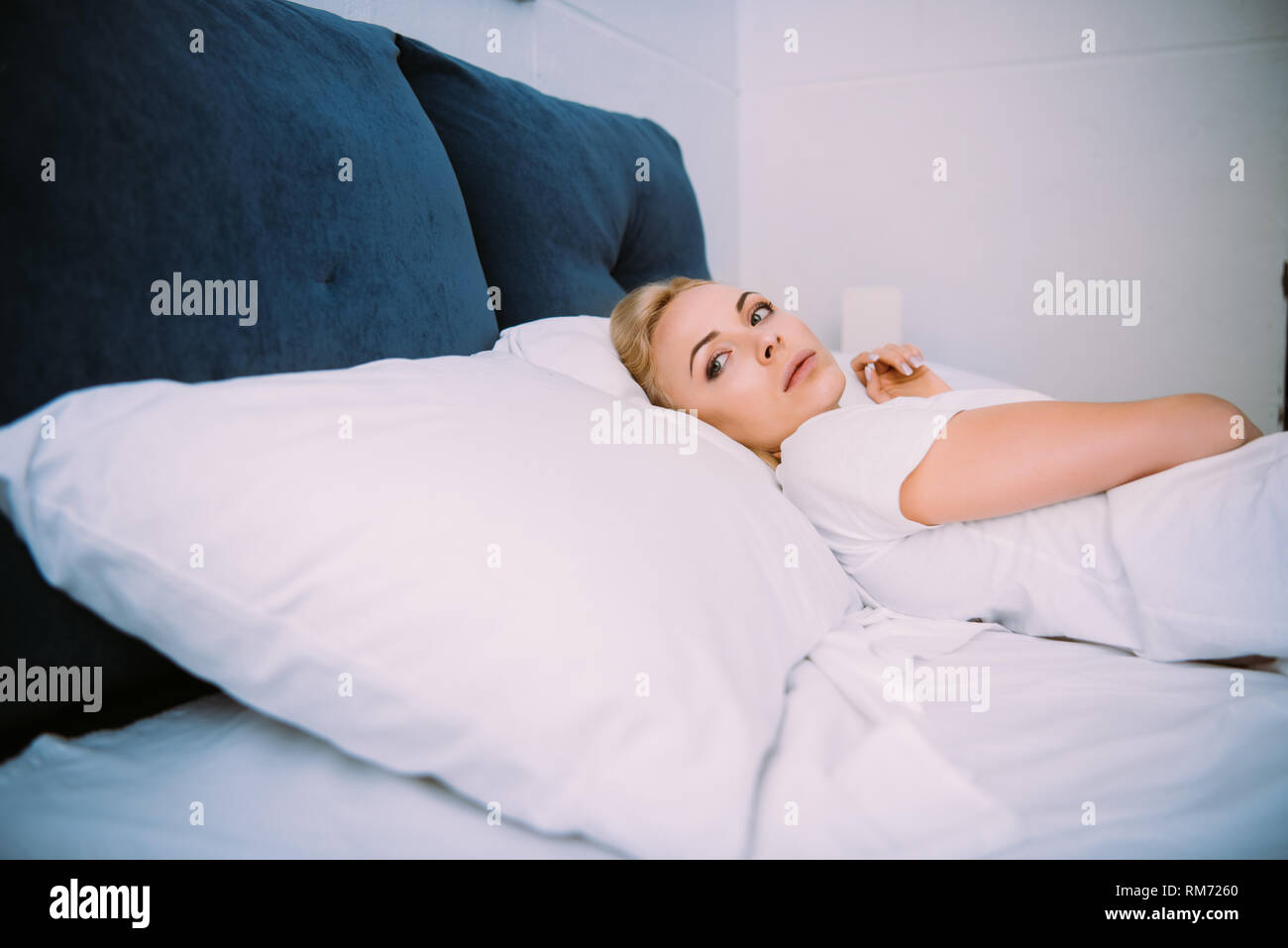 beautiful sad woman lying in bed and looking away Stock Photo - Alamy