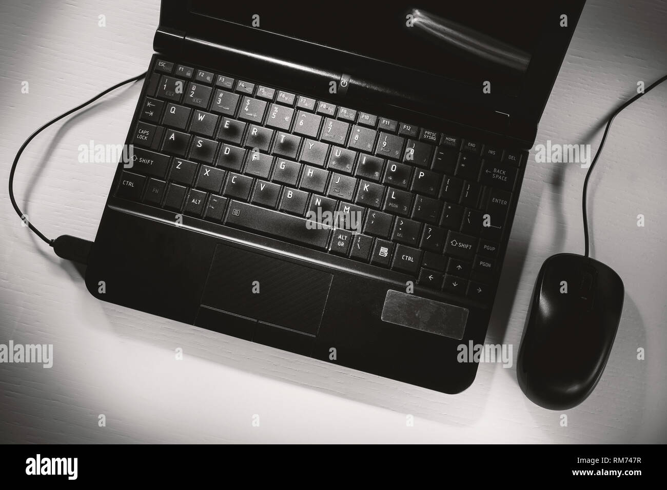 Old and small laptop on white table in black and white Stock Photo - Alamy
