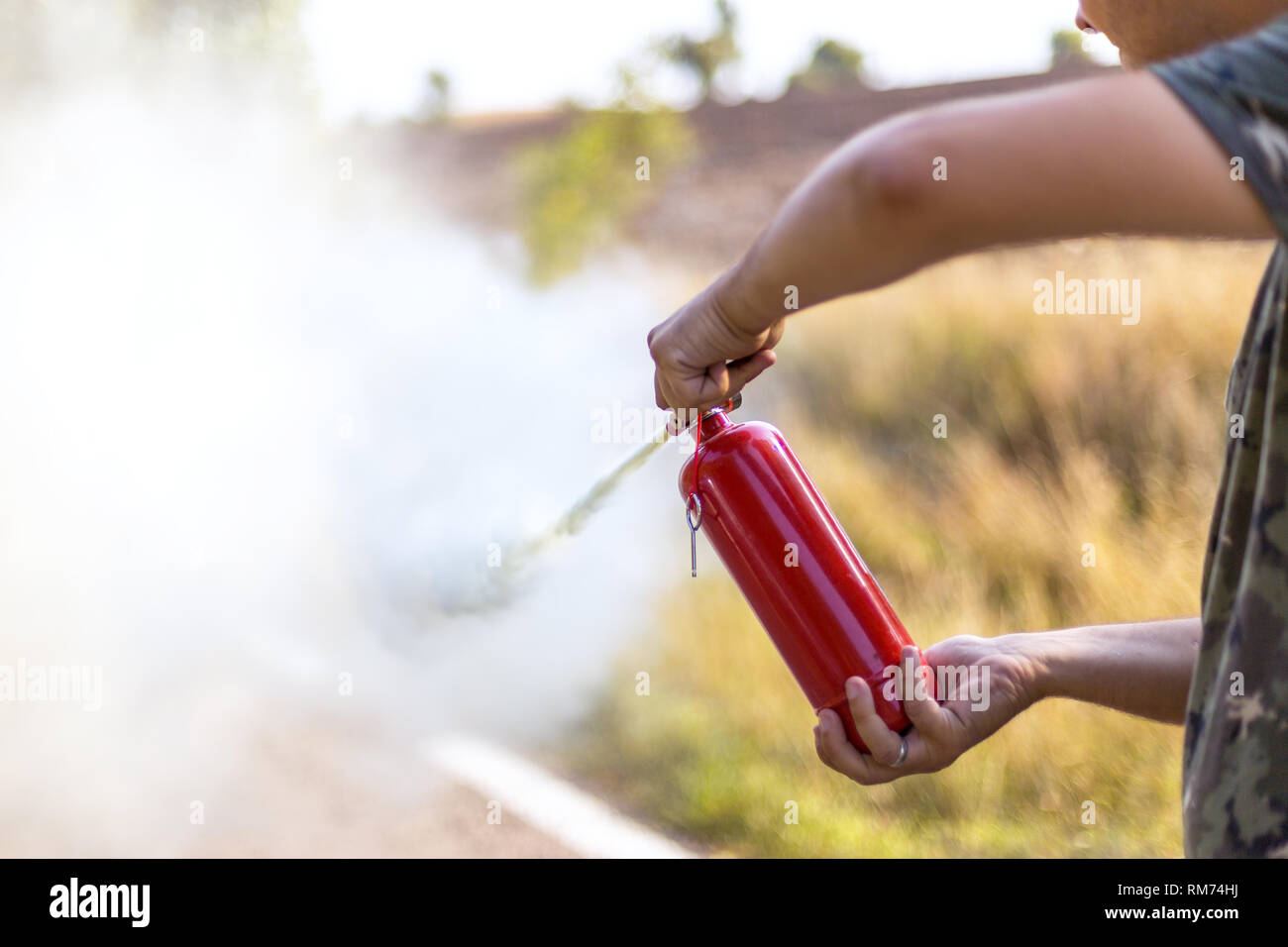 Person with fire extinguishing spraying. A man practises how to use a ...