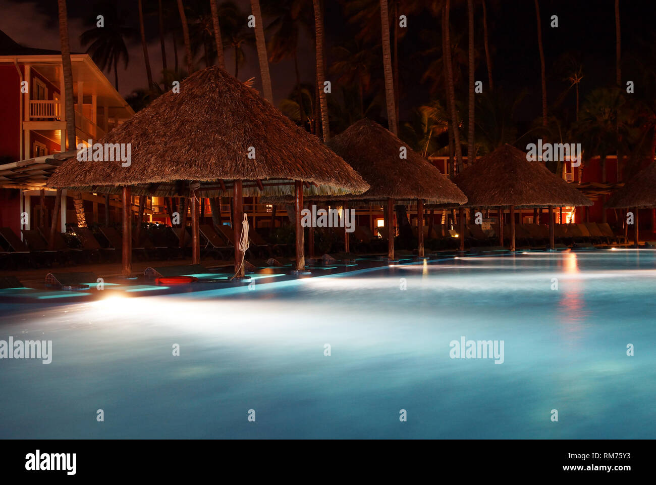 Tropical resort lighted swimming pool at night Stock Photo - Alamy