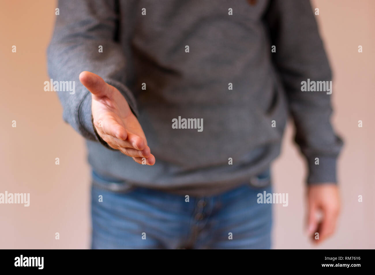 Hand reaching out for a handshake Stock Photo - Alamy