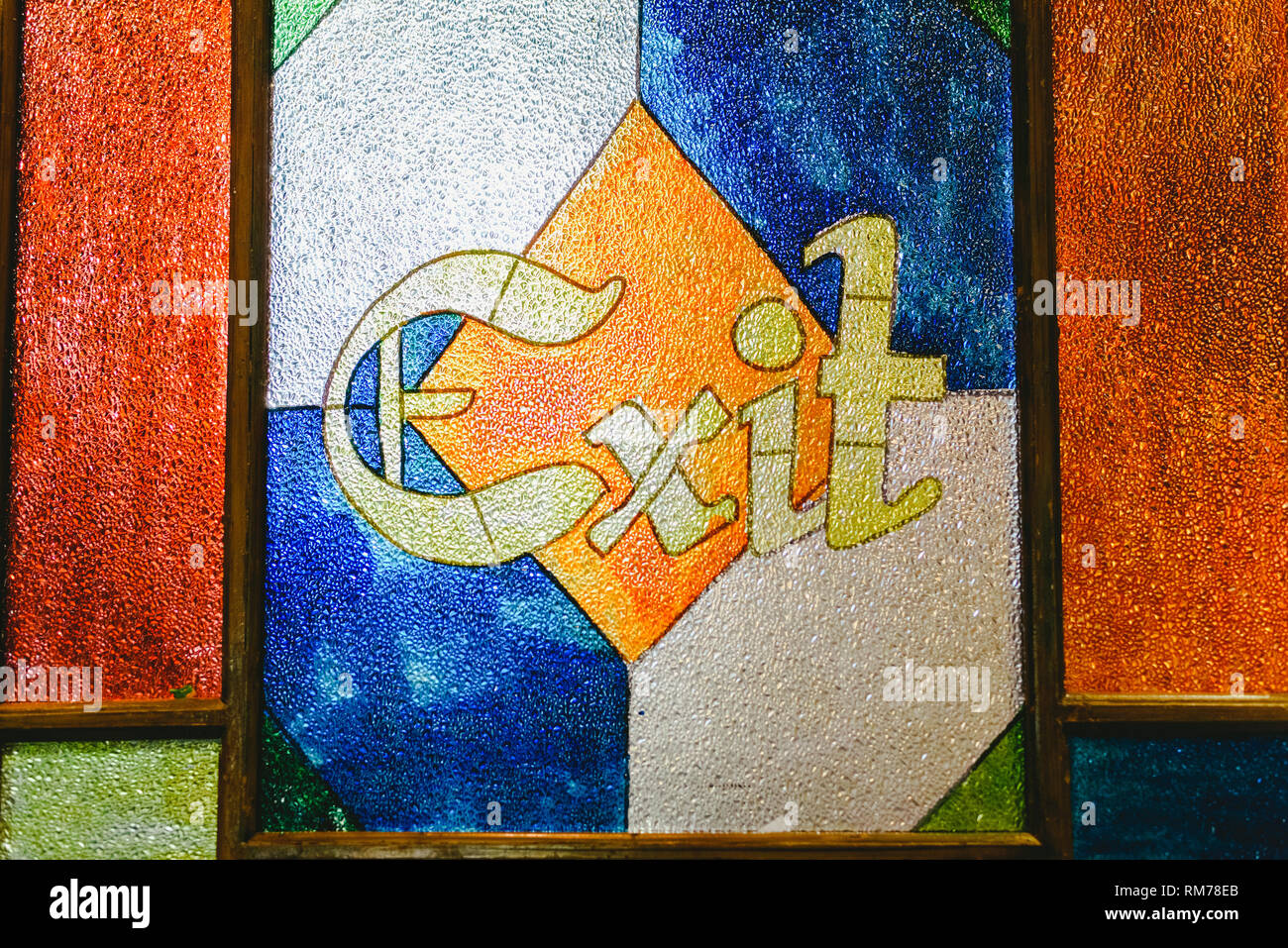 Exit word in an antique engraving on the colorful glass of a door Stock ...