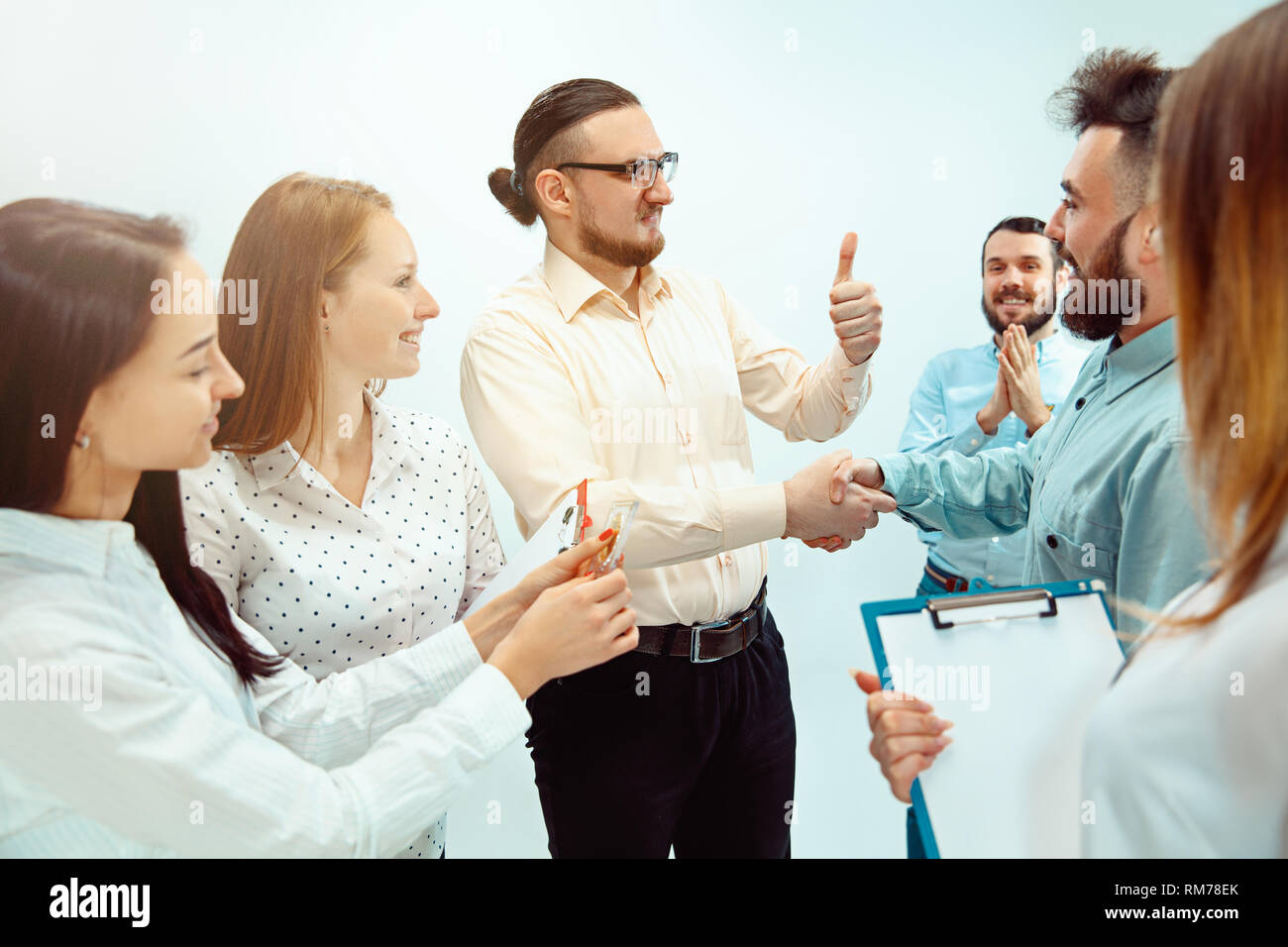 Boss approving and congratulating young successful employee of the ...