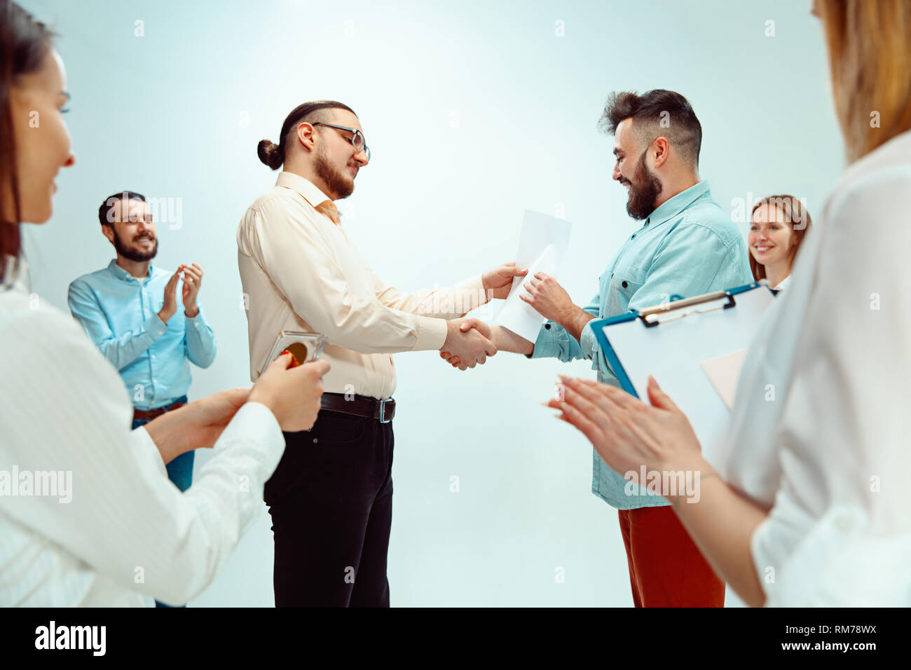 Boss approving and congratulating young successful employee of the ...