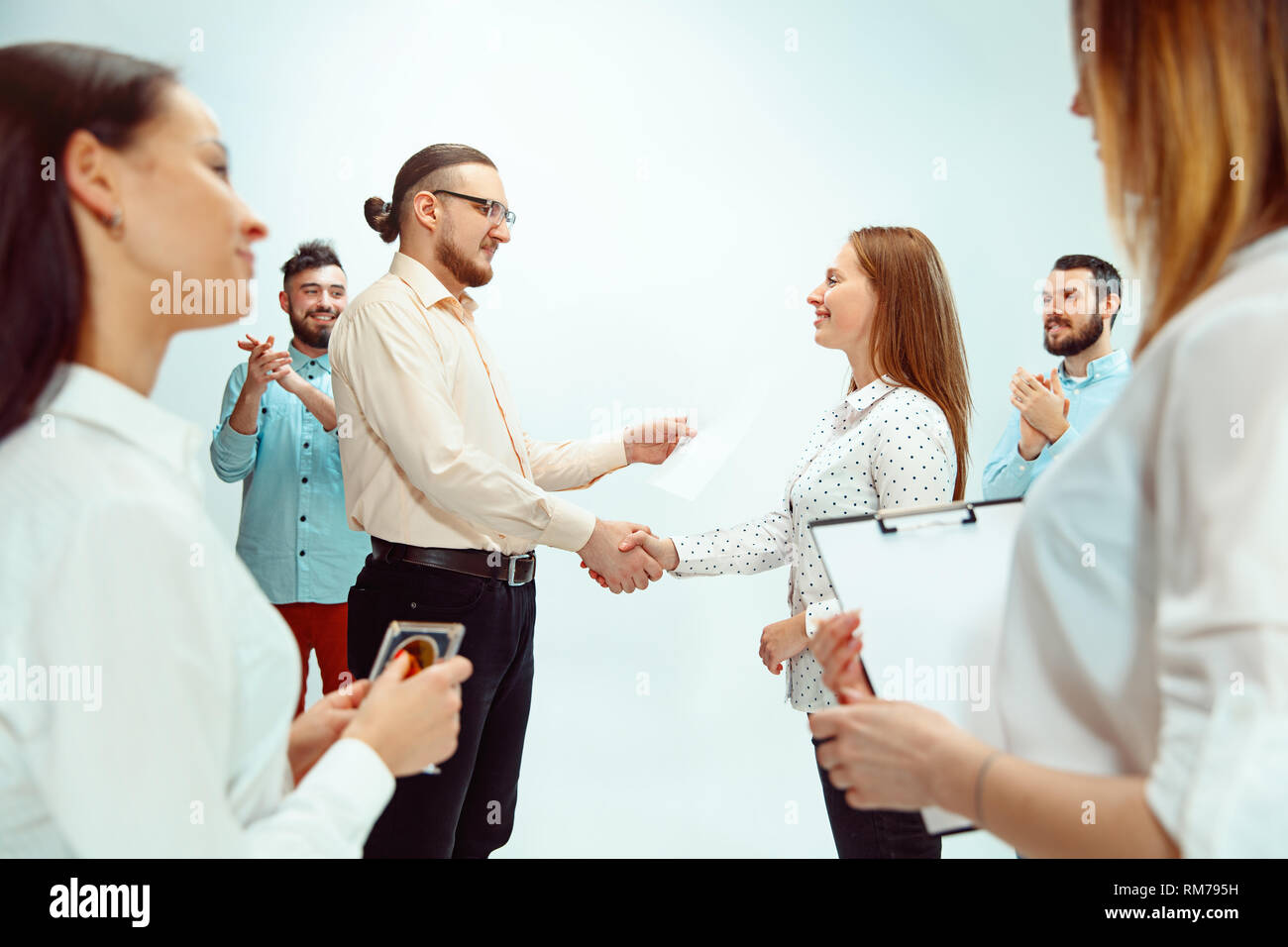 Boss approving and congratulating young successful employee of the ...