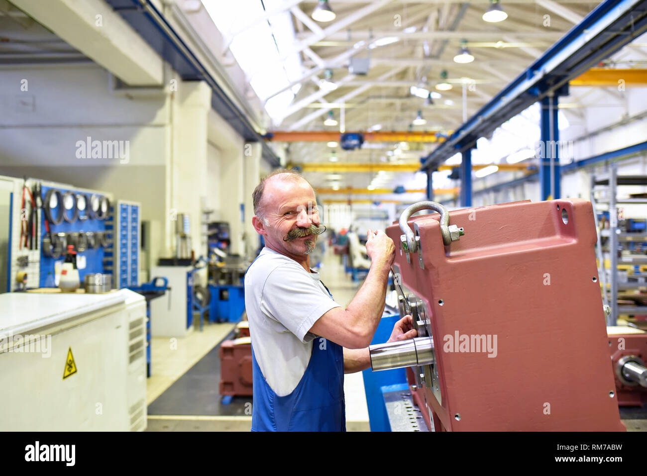 older worker in mechanical engineering - industrial factory for the ...