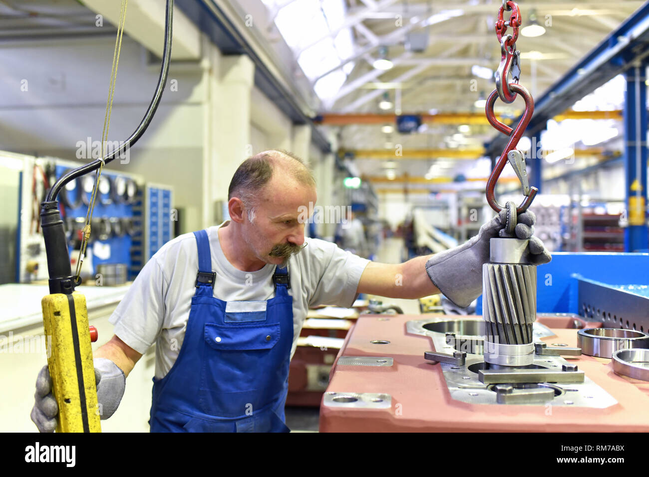 older worker in mechanical engineering - industrial factory for the ...