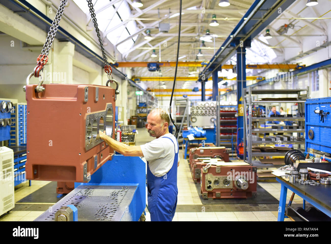 older worker in mechanical engineering - industrial factory for the ...