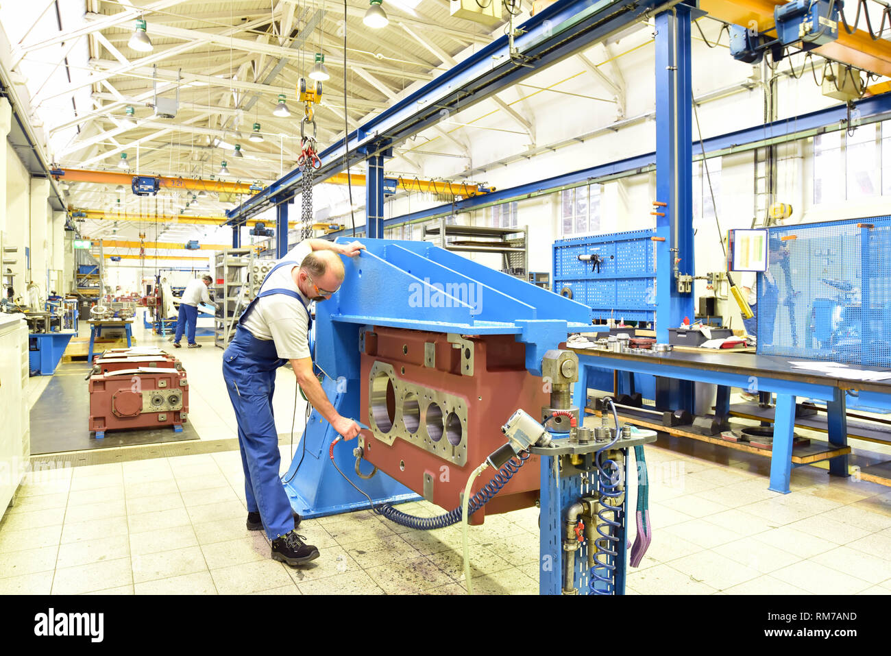 older worker in mechanical engineering - industrial factory for the ...