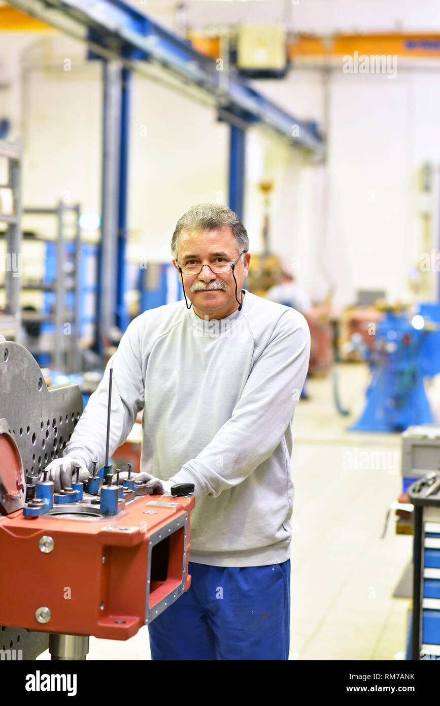 older worker in mechanical engineering - industrial factory for the ...