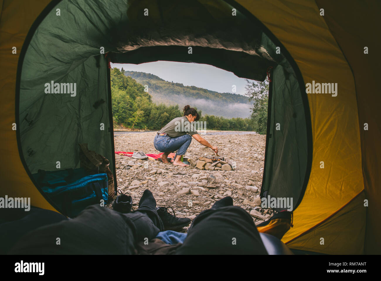 couple resting at nature. camping. cooking on campfire. view from tent ...