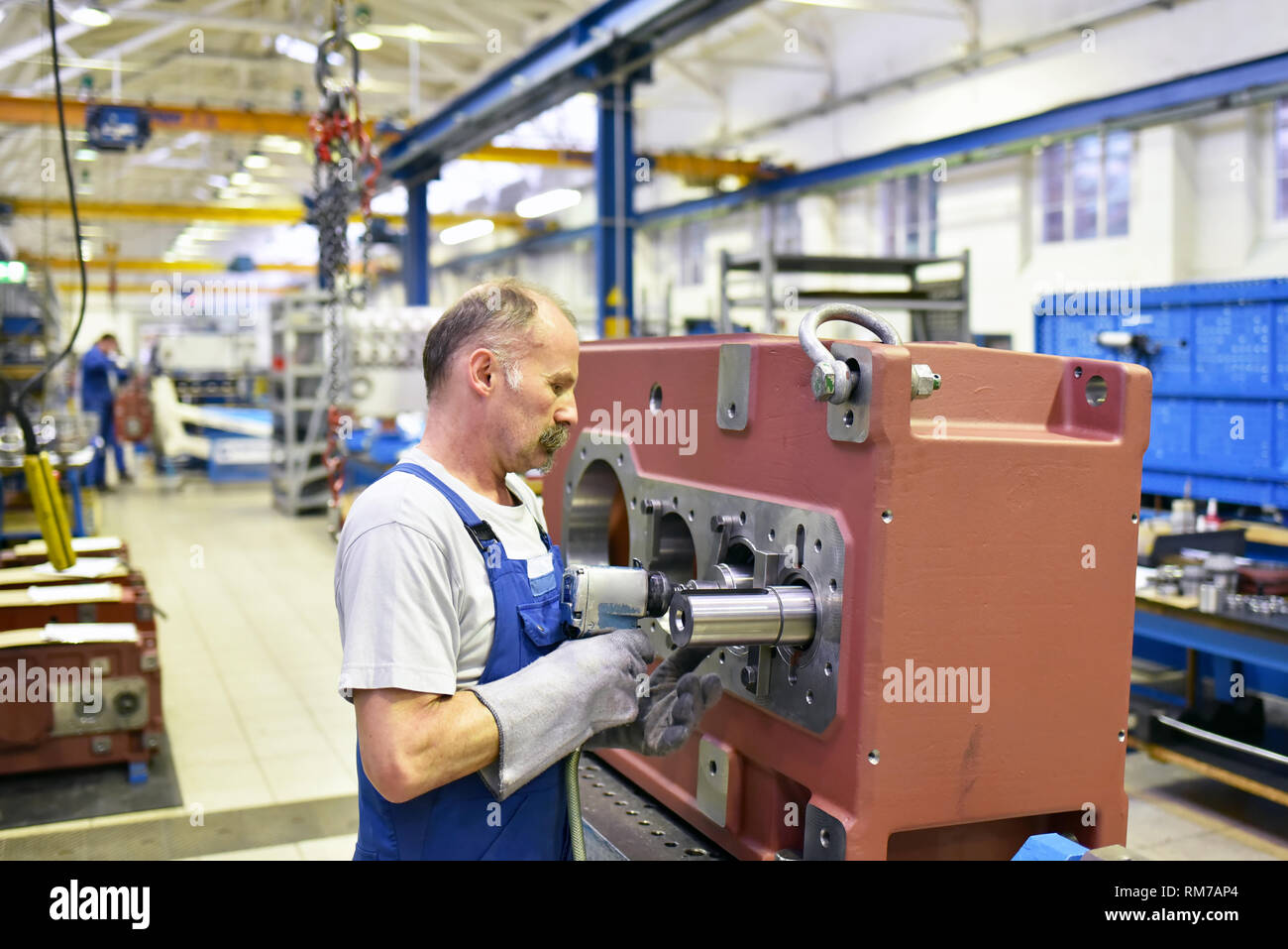 older worker in mechanical engineering - industrial factory for the ...