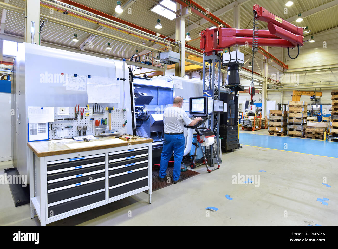 cnc machine in modern industrial mechanical engineering - workers at ...