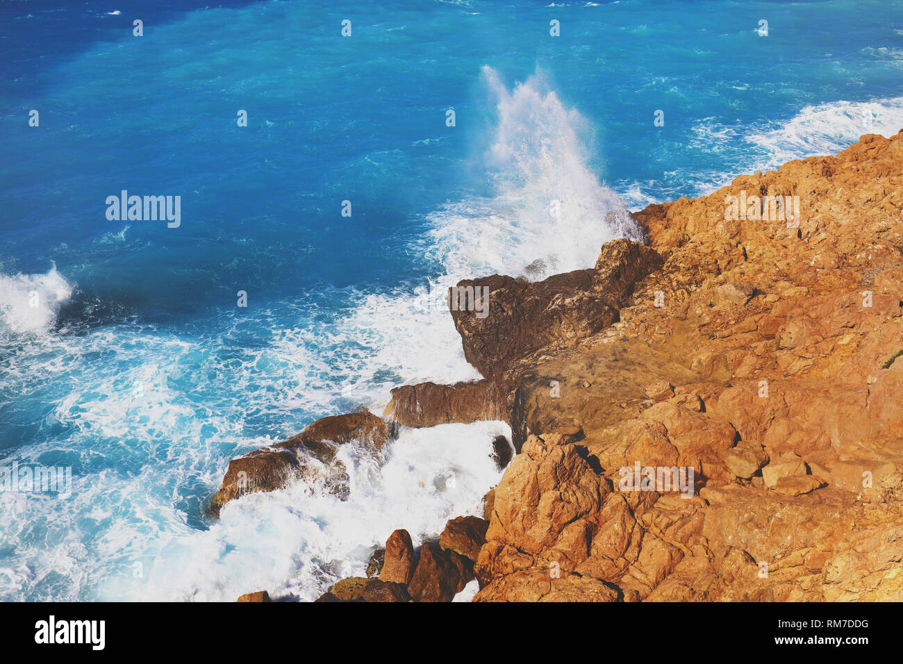 Rocky seashore with beautiful blue water Stock Photo - Alamy