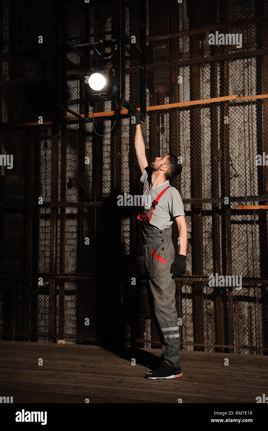 The lighting engineer adjusts the lights on stage behind the scenes ...
