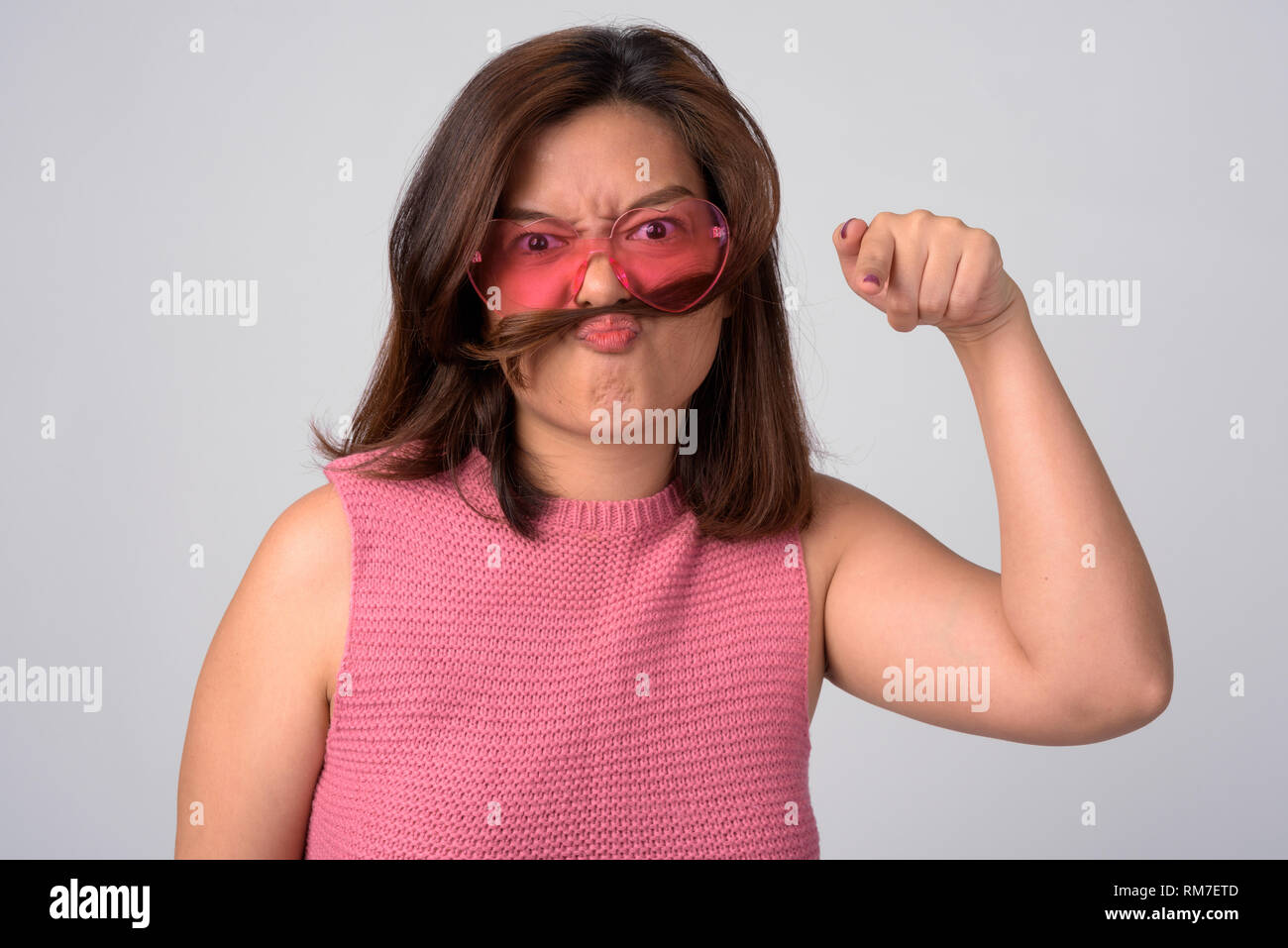 Young angry Asian woman with hair as mustache pointing at camera Stock ...