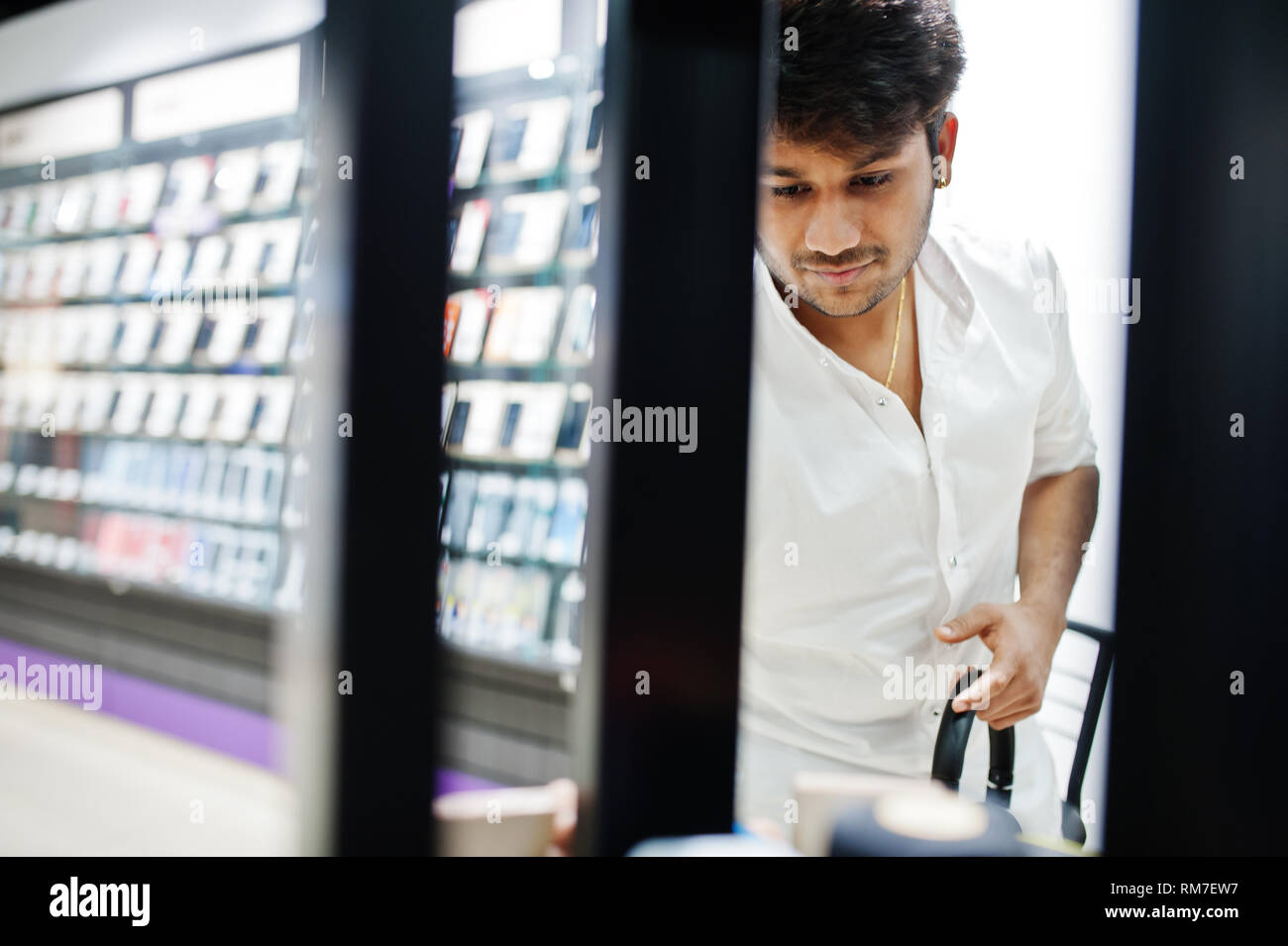 Indian man customer buyer at mobile phone store chooses the goods on ...