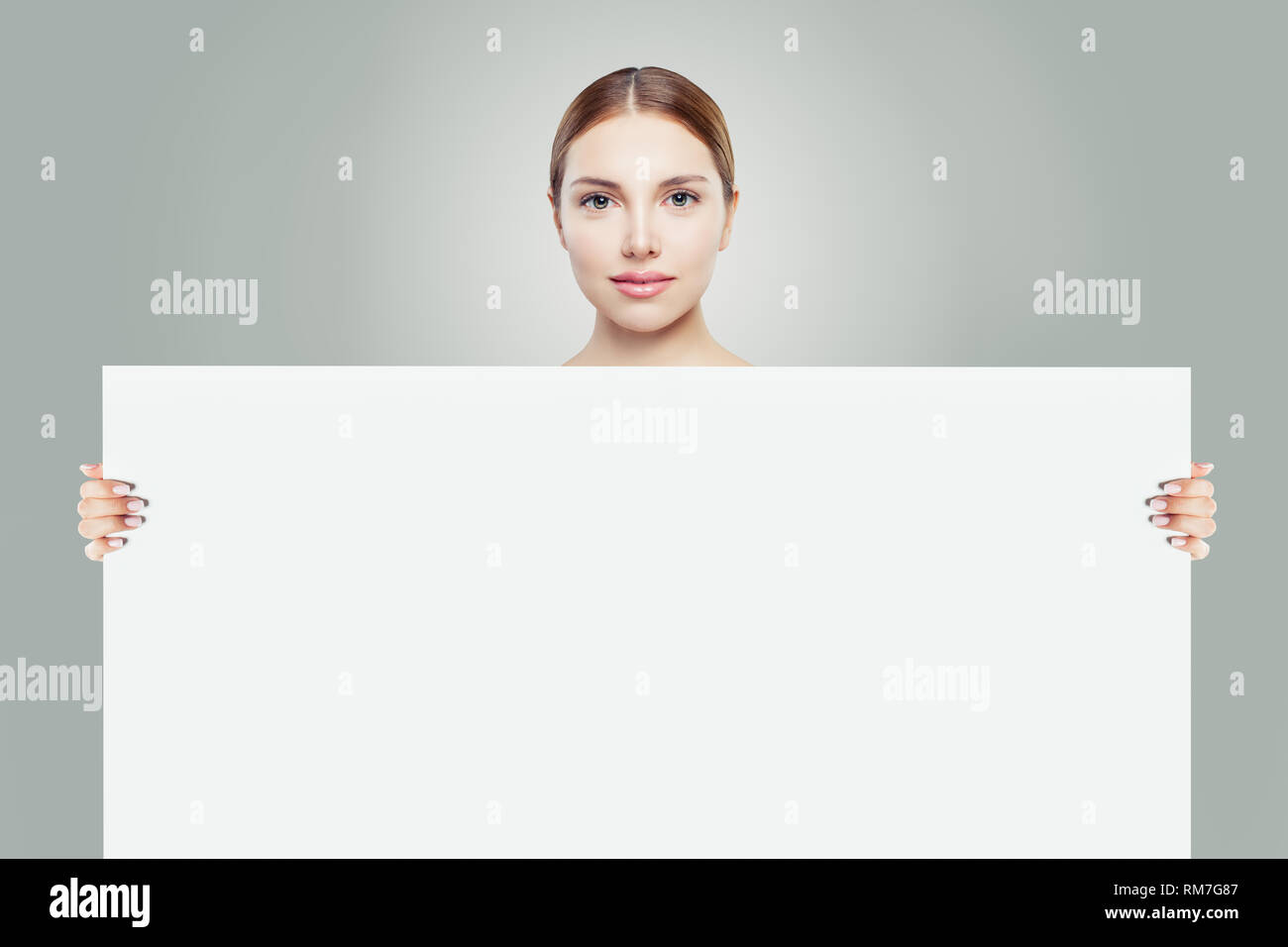 Healthy woman and big white empty paper board background in her hands ...