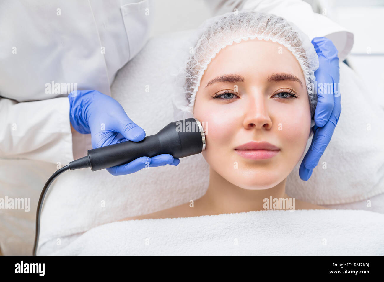 Beautician Makes Ultrasound Massage Procedure On Female Face Stock