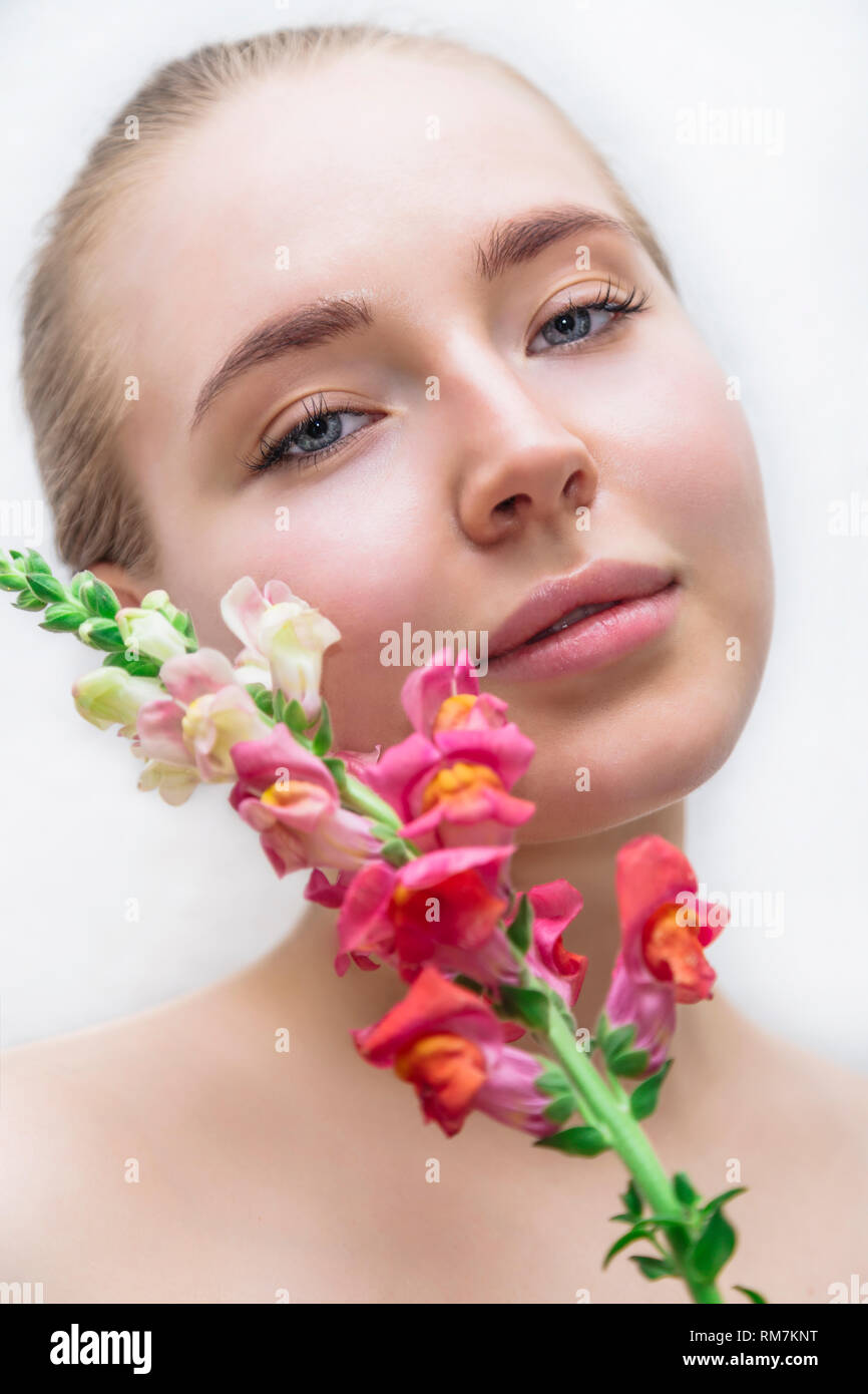 Beautiful girl's face with color flower near Stock Photo - Alamy