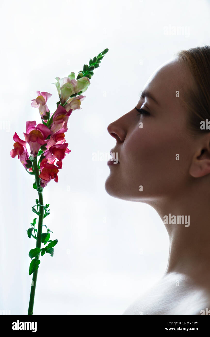 Face of young girl in profile sniffing flower Stock Photo - Alamy