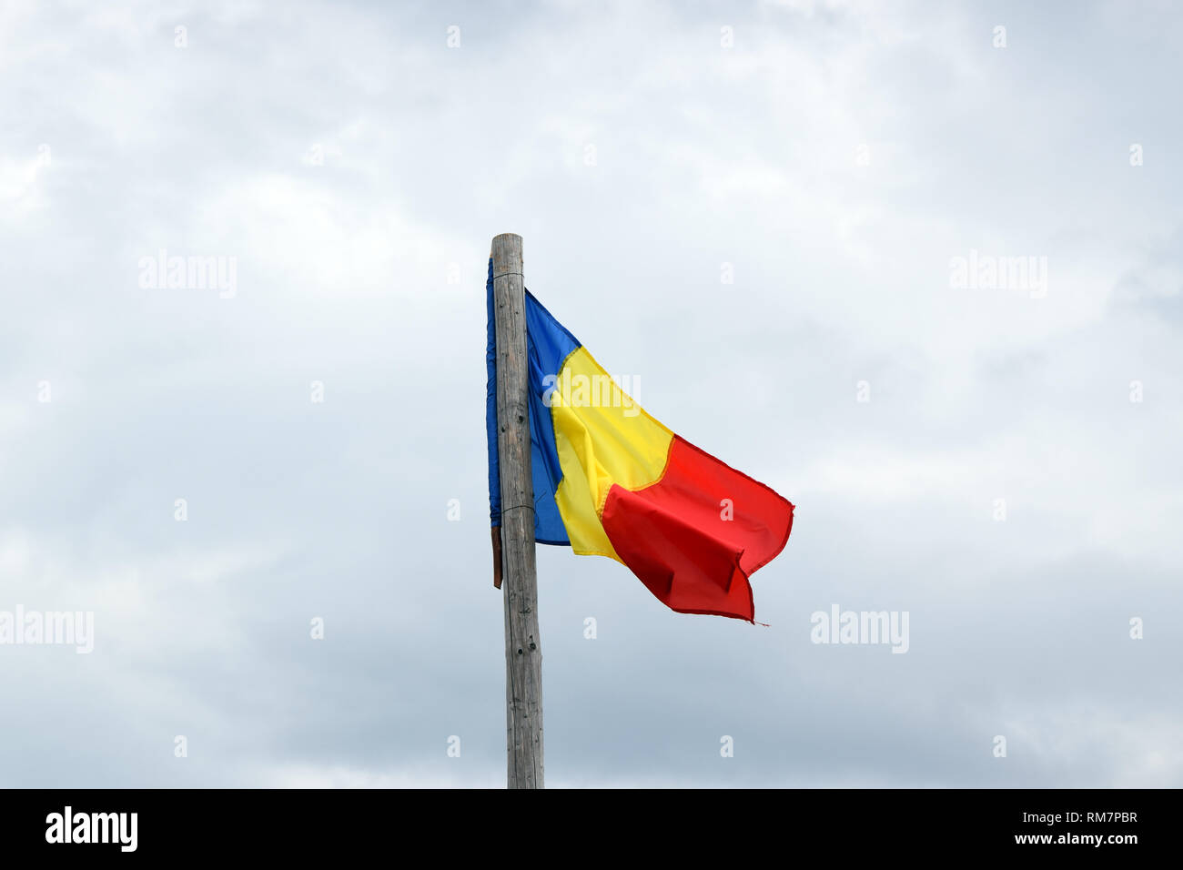 Romanian flag waving in the wind in front of a clean blue sky. Romania ...