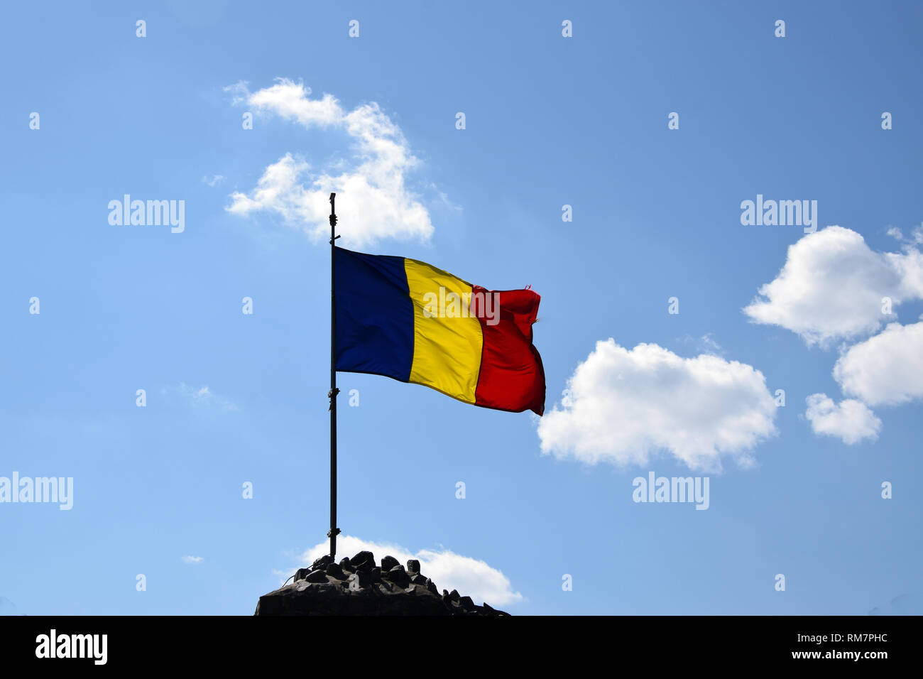 Romanian flag waving in the wind in front of a clean blue sky. Romania ...