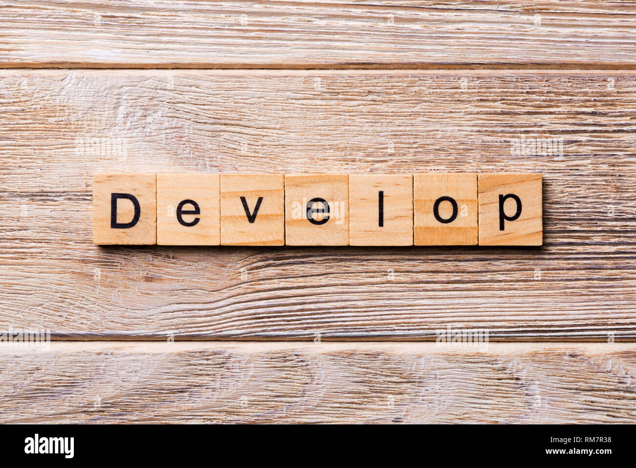 Develop word written on wood block. Develop text on wooden table for ...