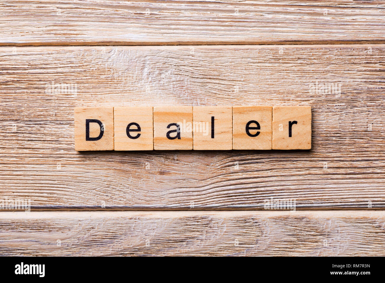 Dealer word written on wood block. Dealer text on wooden table for your ...