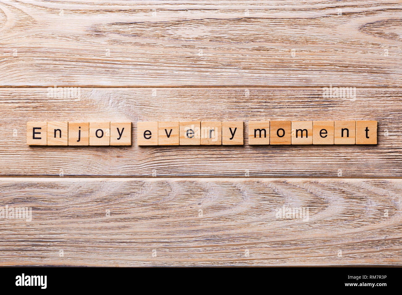 Enjoy Every Moment word written on wood block. Enjoy Every Moment text ...