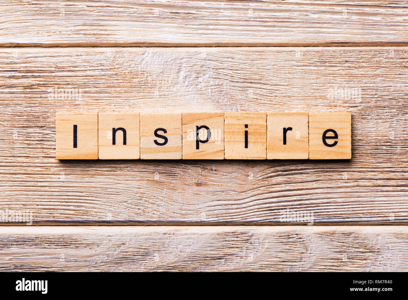 Inspire word written on wood block. Inspire text on wooden table for ...