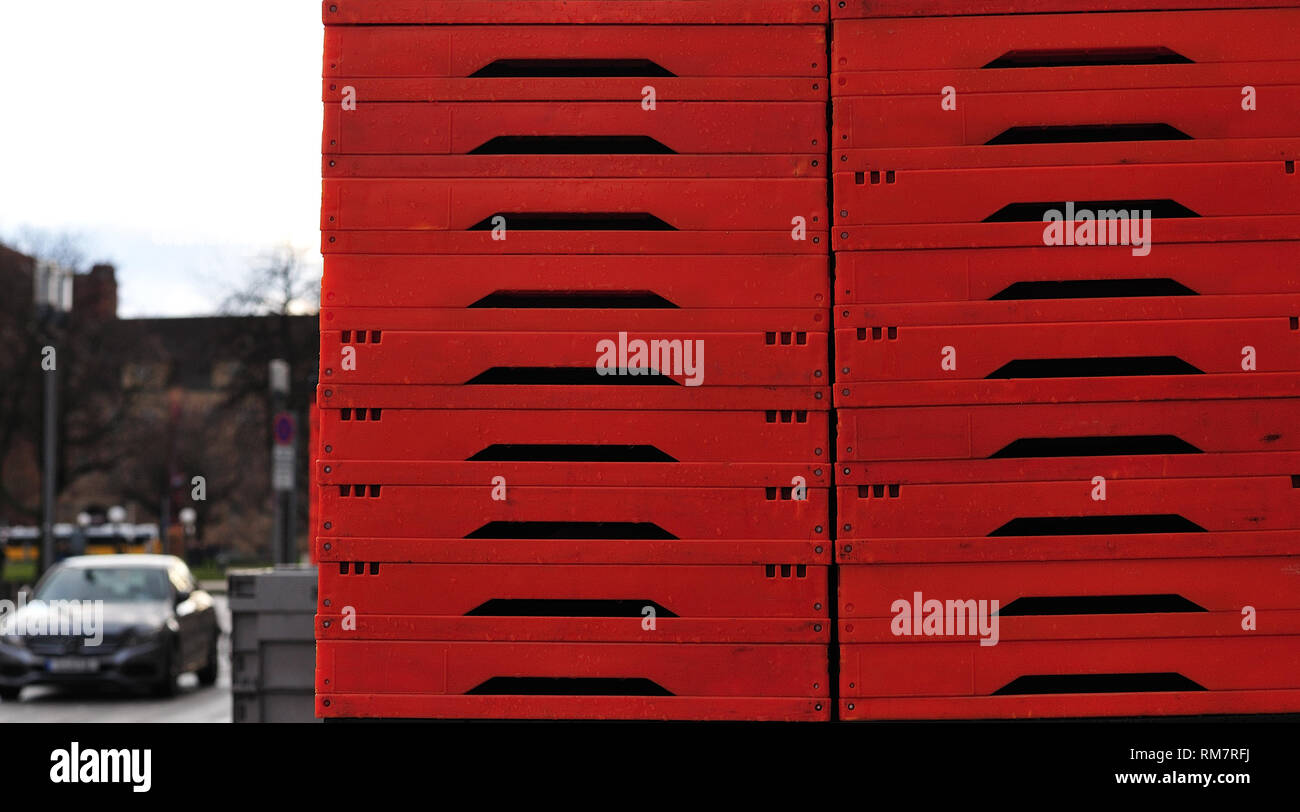 red foldable plastic boxes stacked up on sidewalk in a city street ...