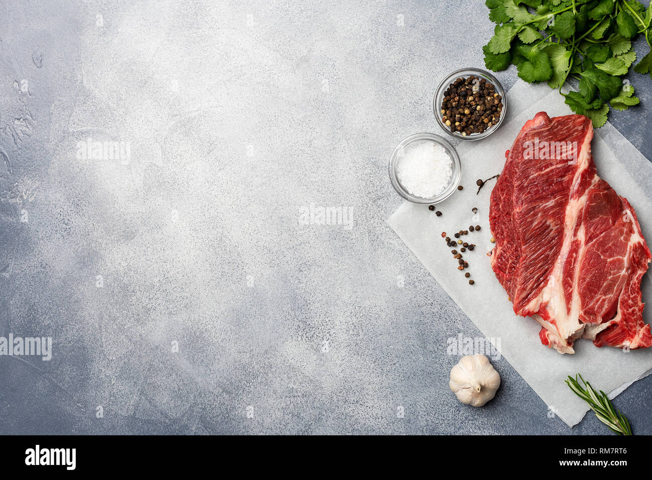 Frame with fresh beef and herbs, condiments and garlic at gray ...