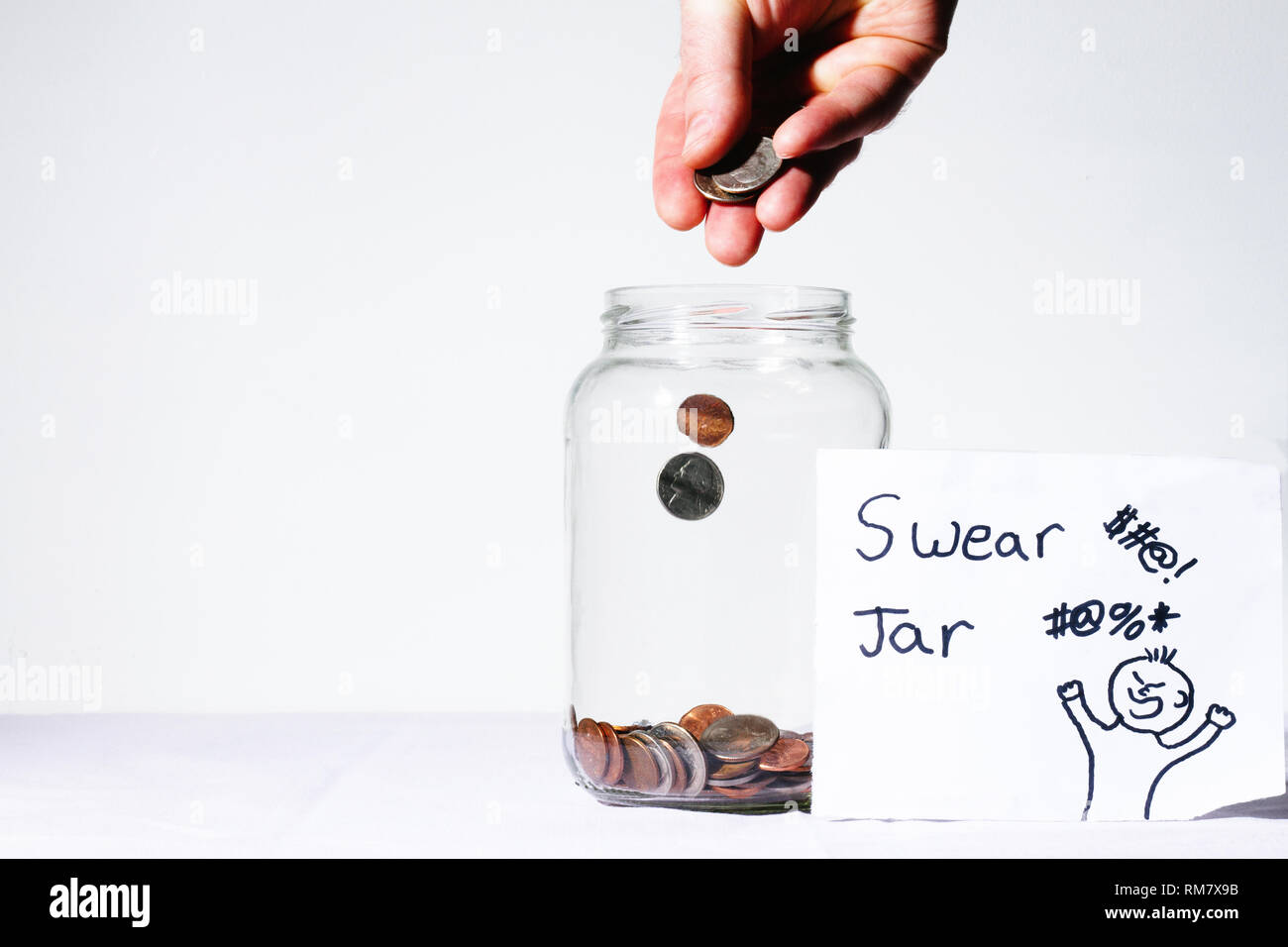 Swear Jar with hand dropping coins and handwritten sign Stock Photo - Alamy