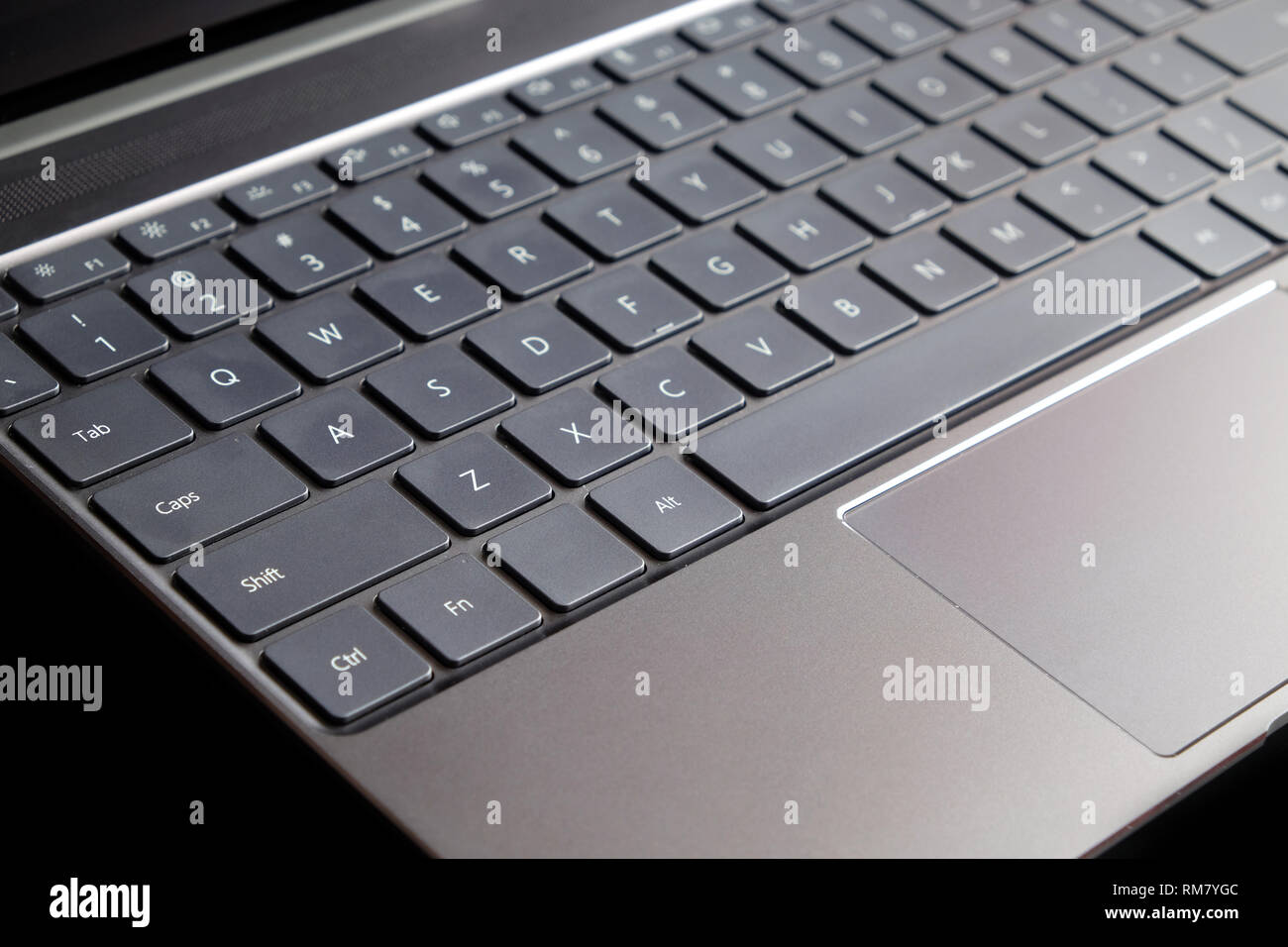 Part of opened laptop with keyboard, touchpad and empty mirror screen ...